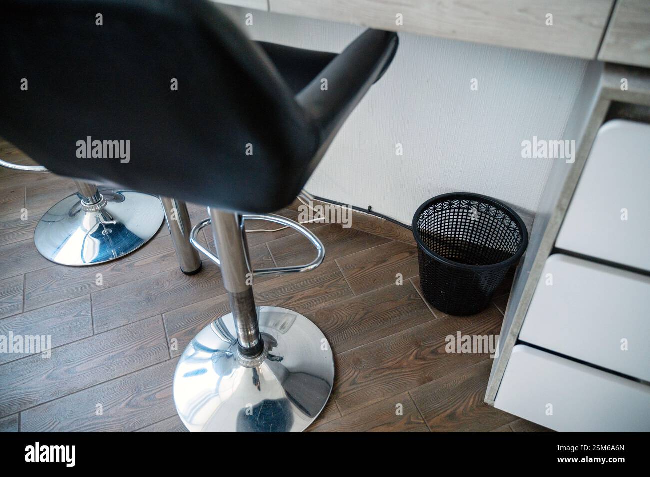 trash can in the office. next to it there is a chair on a high steel ...