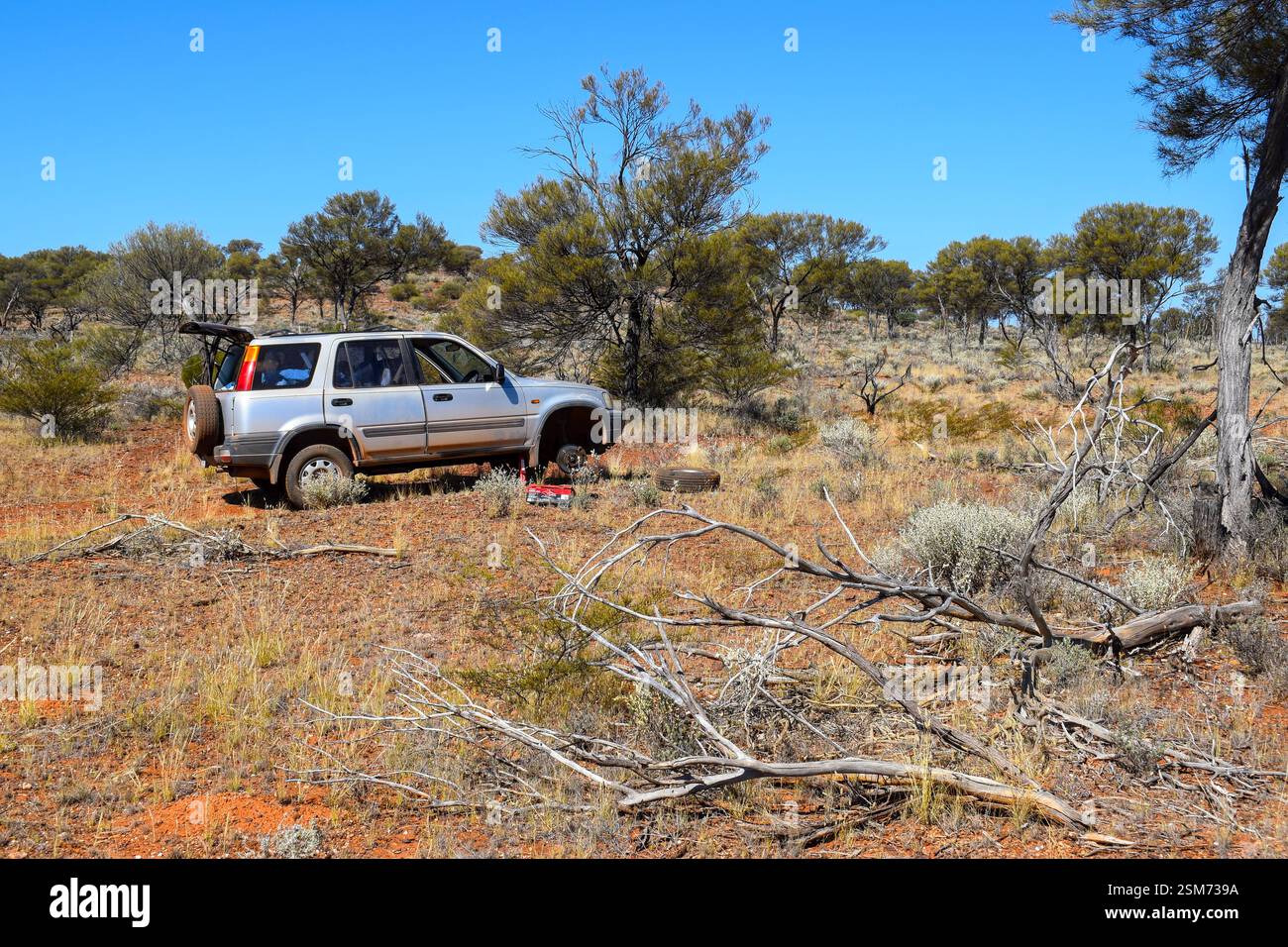 A stranded car with a flat tire in the remote Australian outback ...