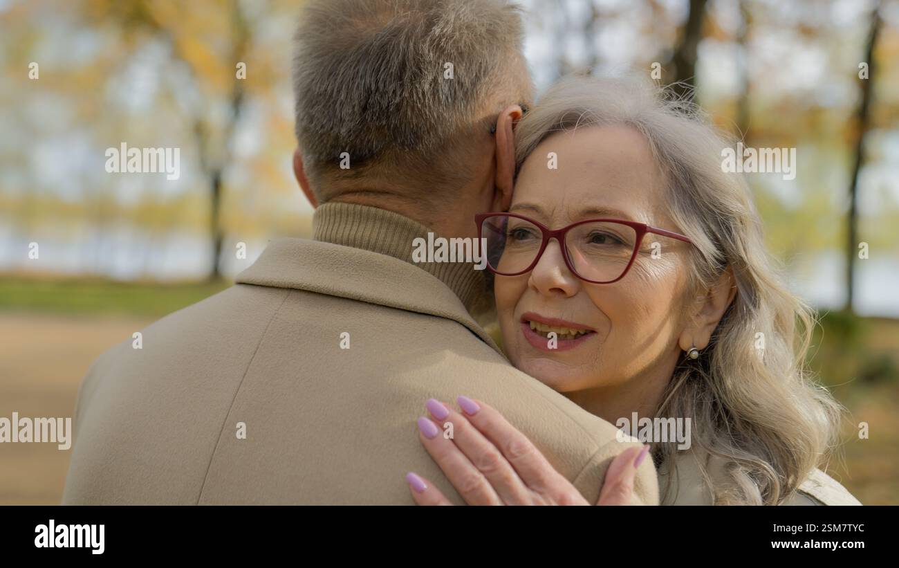 Mature gray-haired woman hugging elderly man tender moment meeting old ...