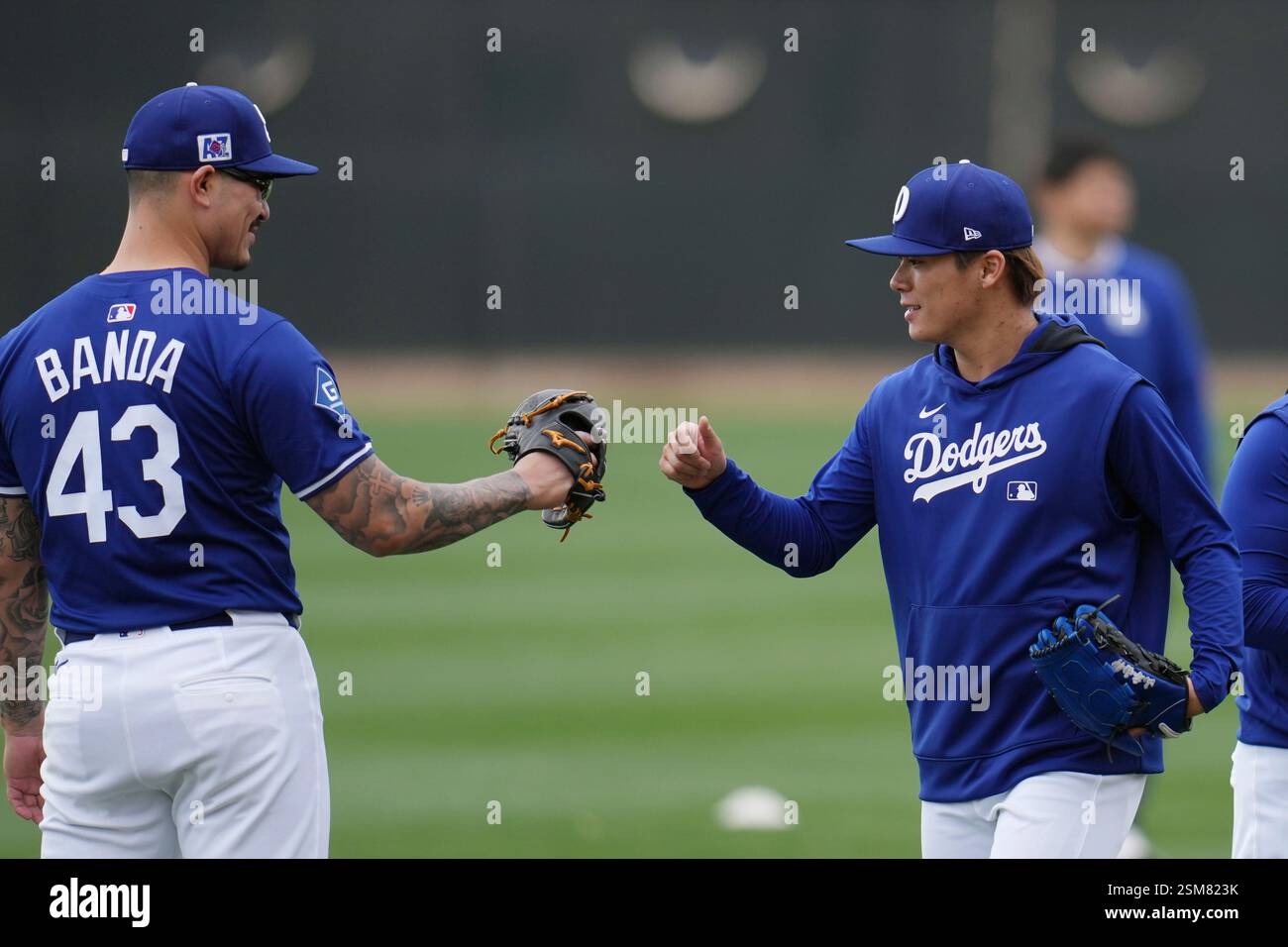 Los Angeles Dodgers pitcher Yoshinobu Yamamoto, right, of Japan, gives ...