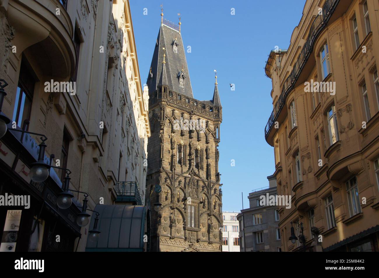 Gothic architecture dominates the narrow street, with a tall, pointed ...
