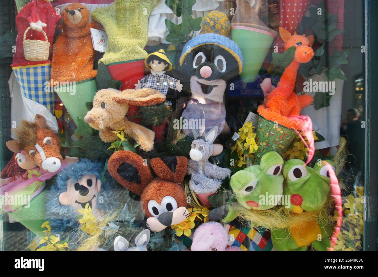 Toy shop window with stuffed animals and puppets on display. Brightly ...
