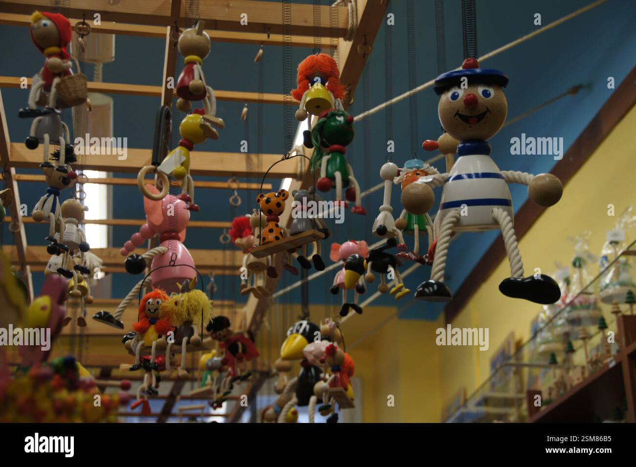 Wooden puppets hang from ceiling. Brightly colored and detailed ...