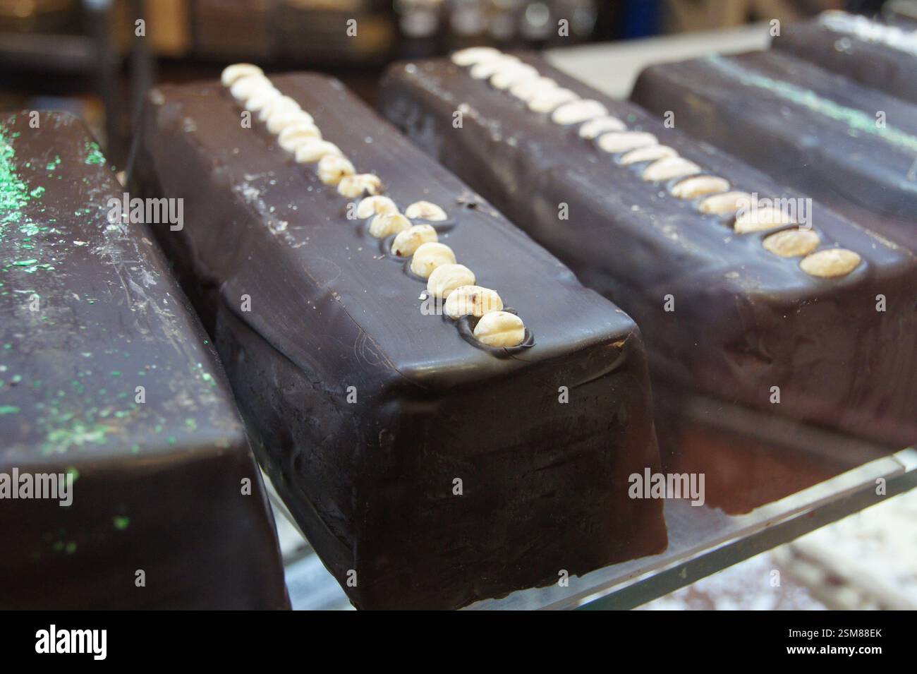 Food display case filled with rows of chocolate turrón. Traditional ...