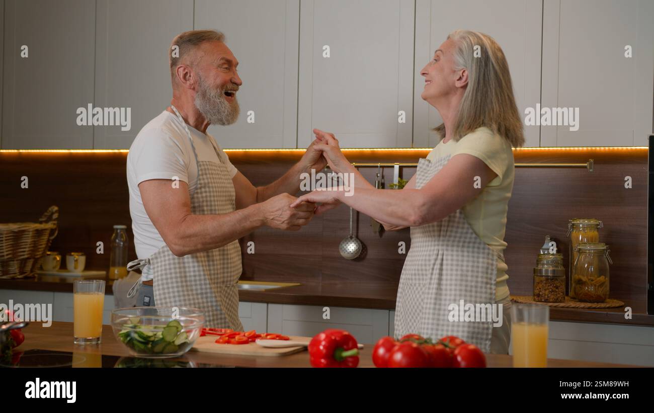 Romantic senior retired Caucasian family couple dancing waltz celebrate ...