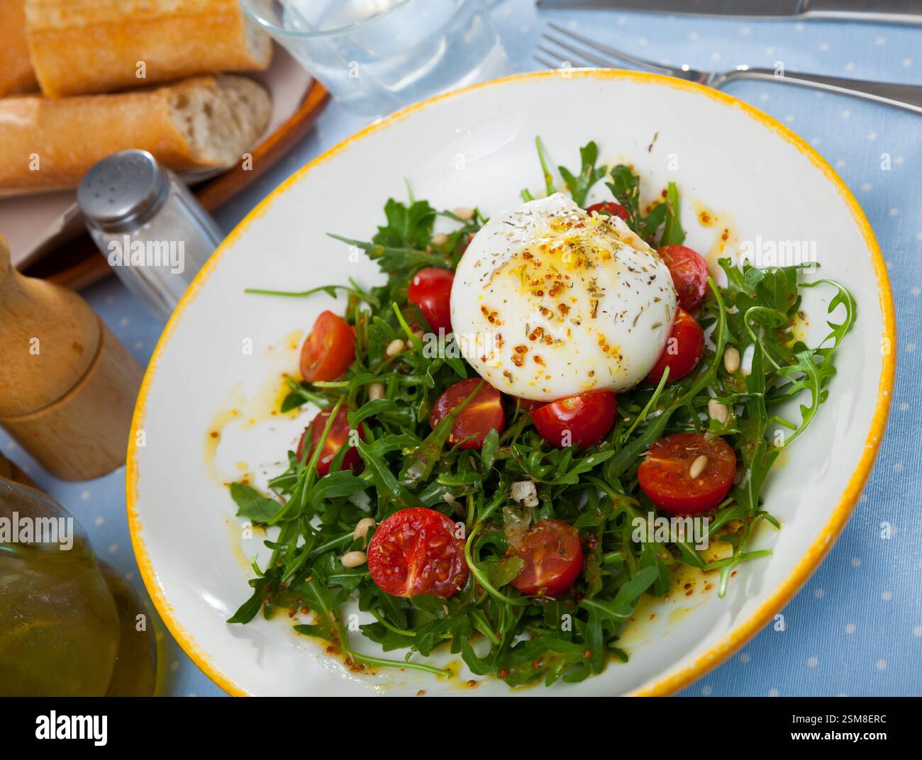Salad with burrata cheese, pine nuts, cherry tomatoes and arugula Stock ...