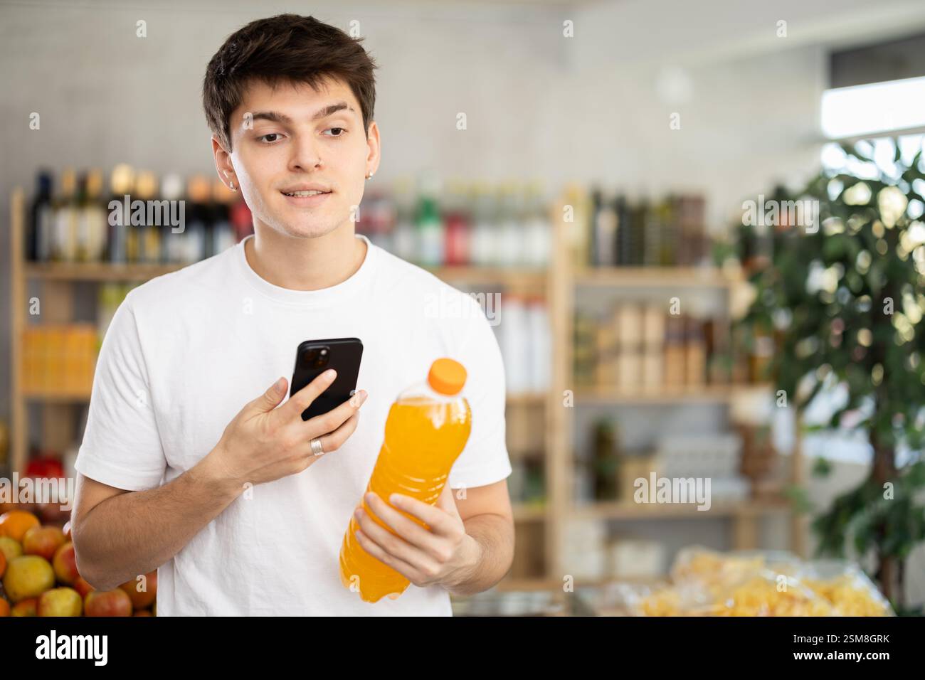 Guy purchaser scanning QR code or barcode bottle of water in ...