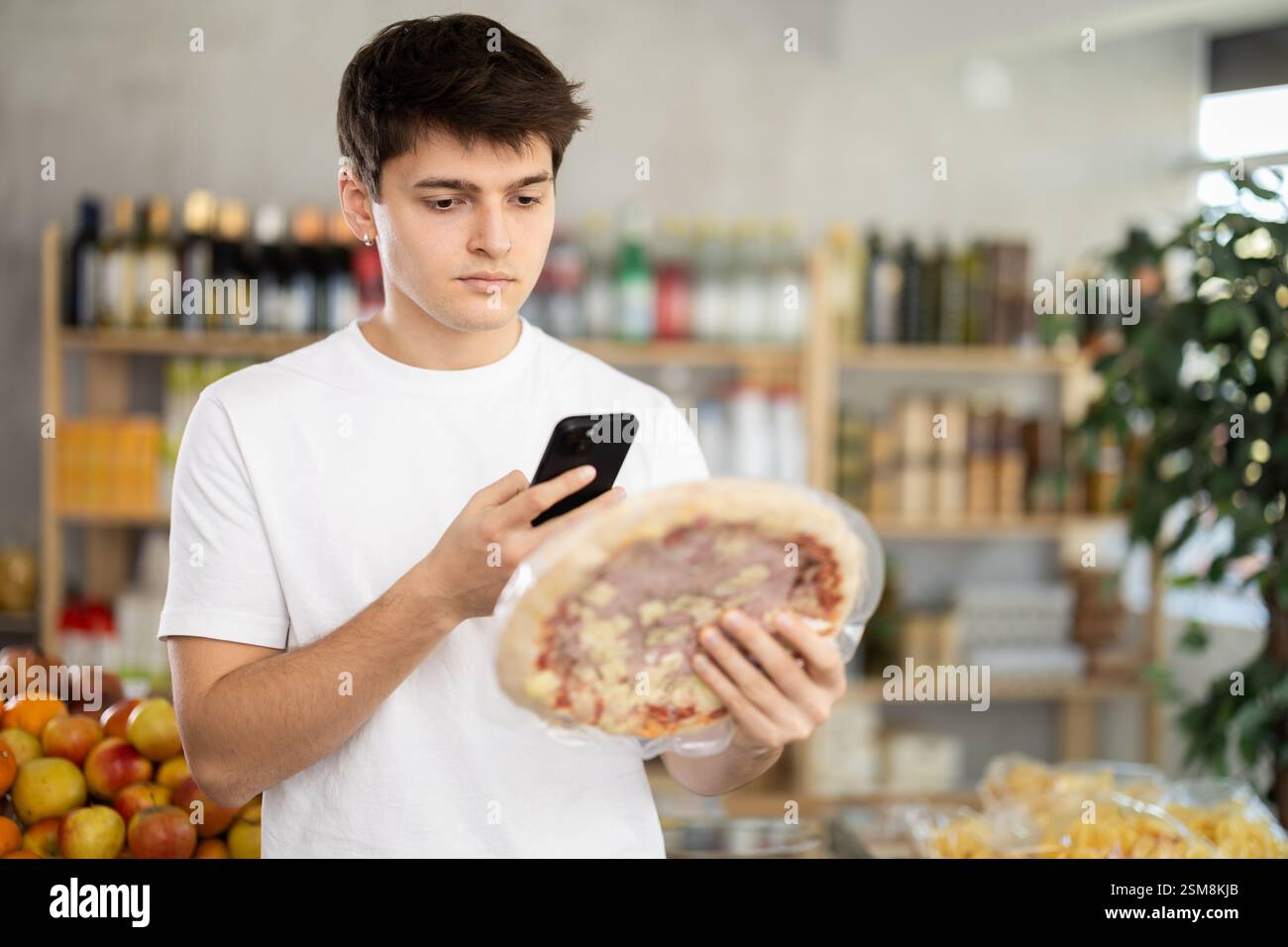 Male shopper scans QR code on four cheese pizza with smartphone Stock ...