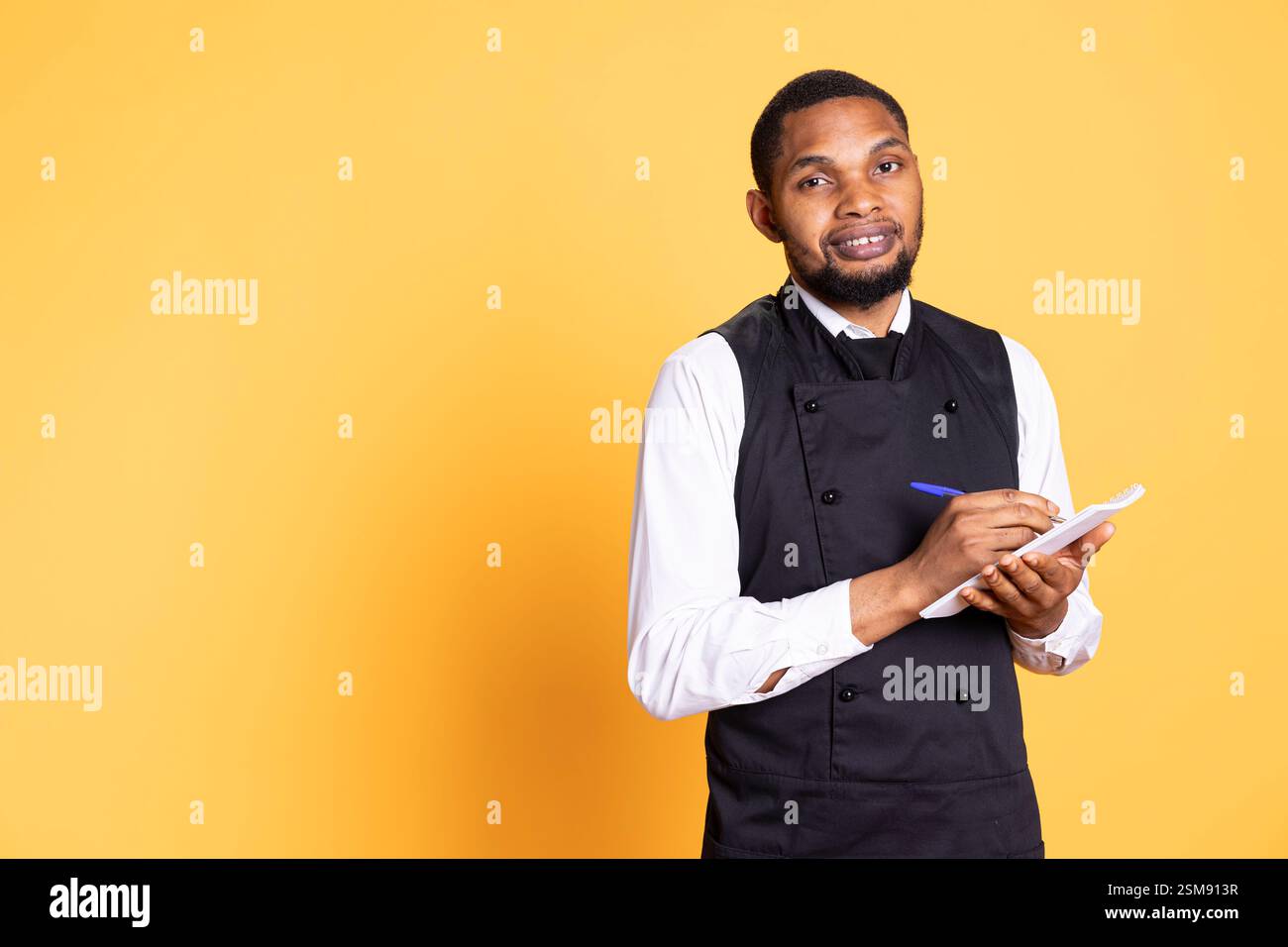 Professional butler writing the order of the clients on notepad, takes ...