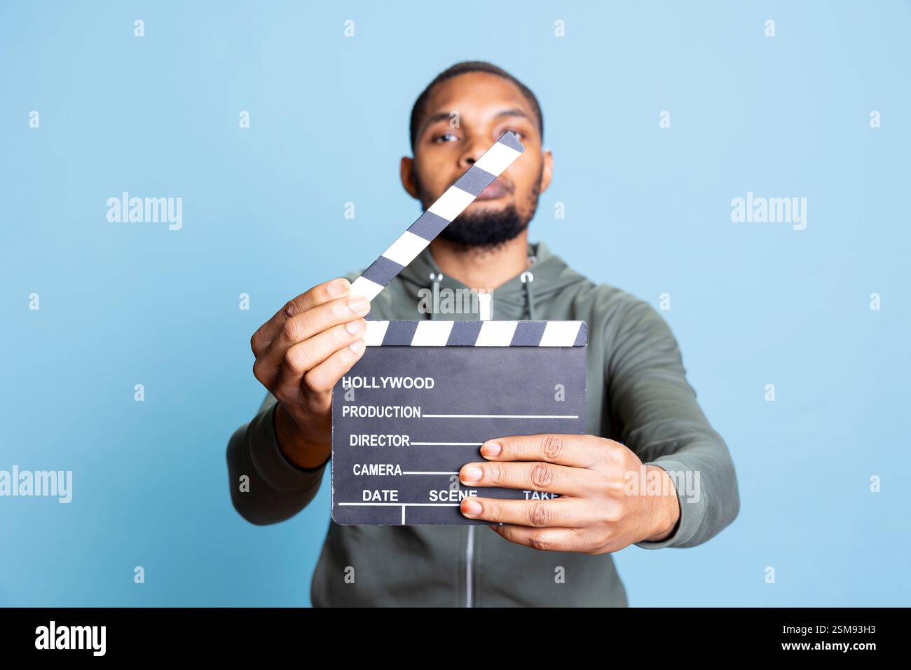 Smiling african american film producer posing with a clapperboard ...