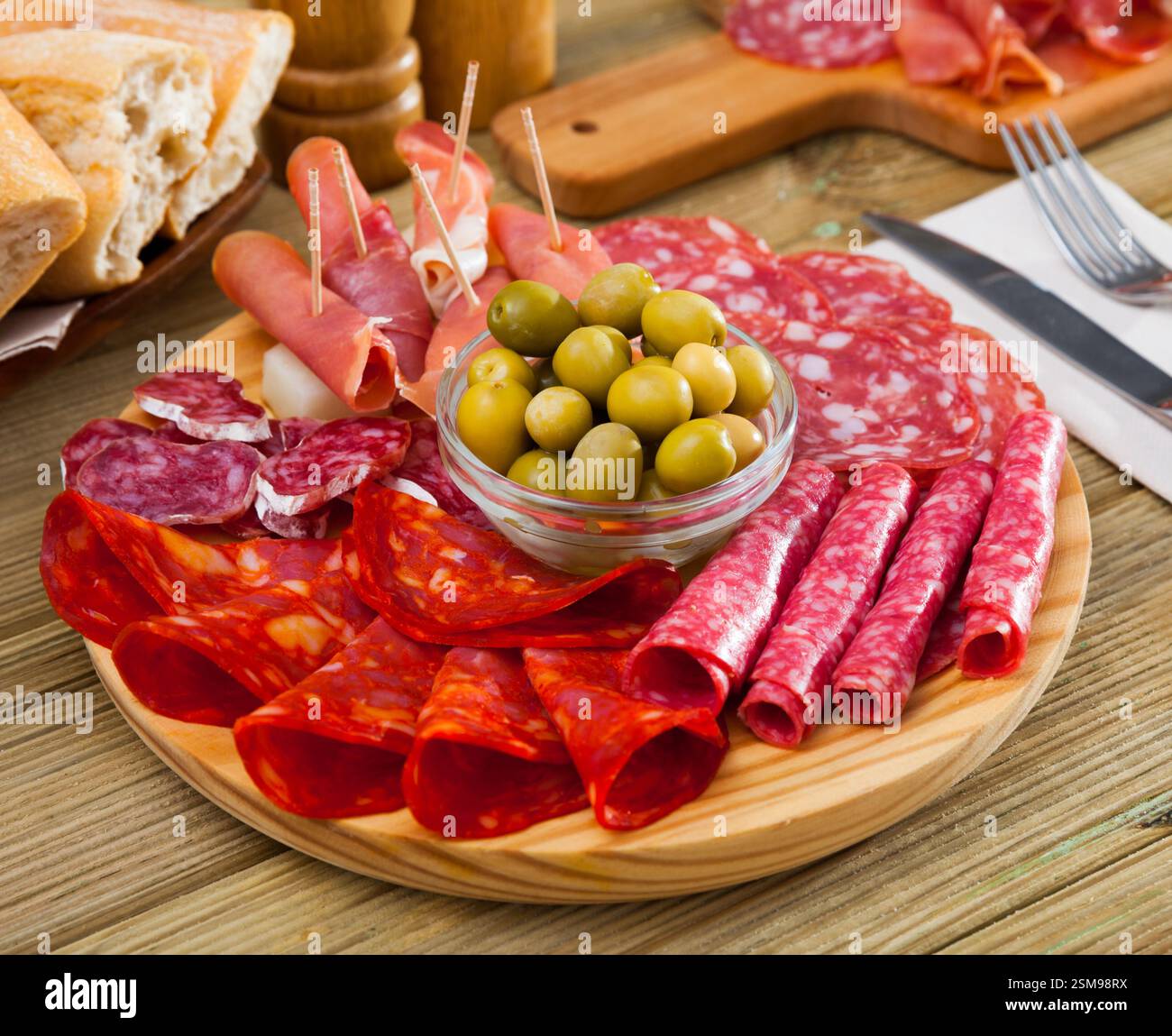 Cold cuts from ham, sausages on wooden plate Stock Photo - Alamy