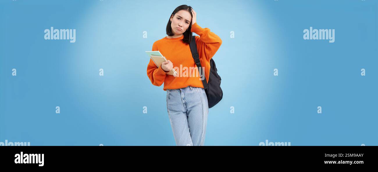 Sad girl student, touches her head and sulks, looks tired after college ...