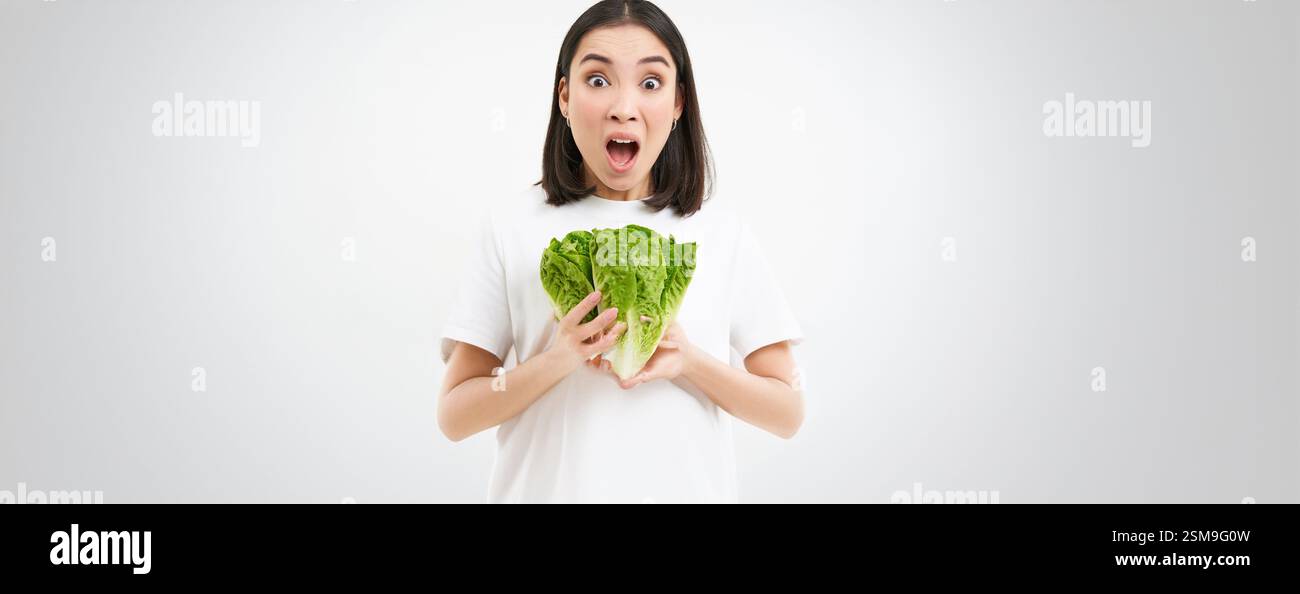 Woman with shocked face, screams, holds vegetable, raw food, eats ...