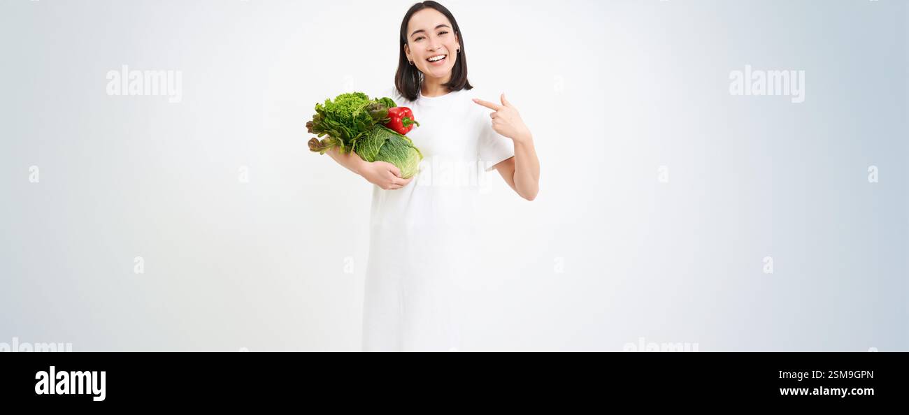 Image of happy korean woman, pointing at vegetables, smiling ...