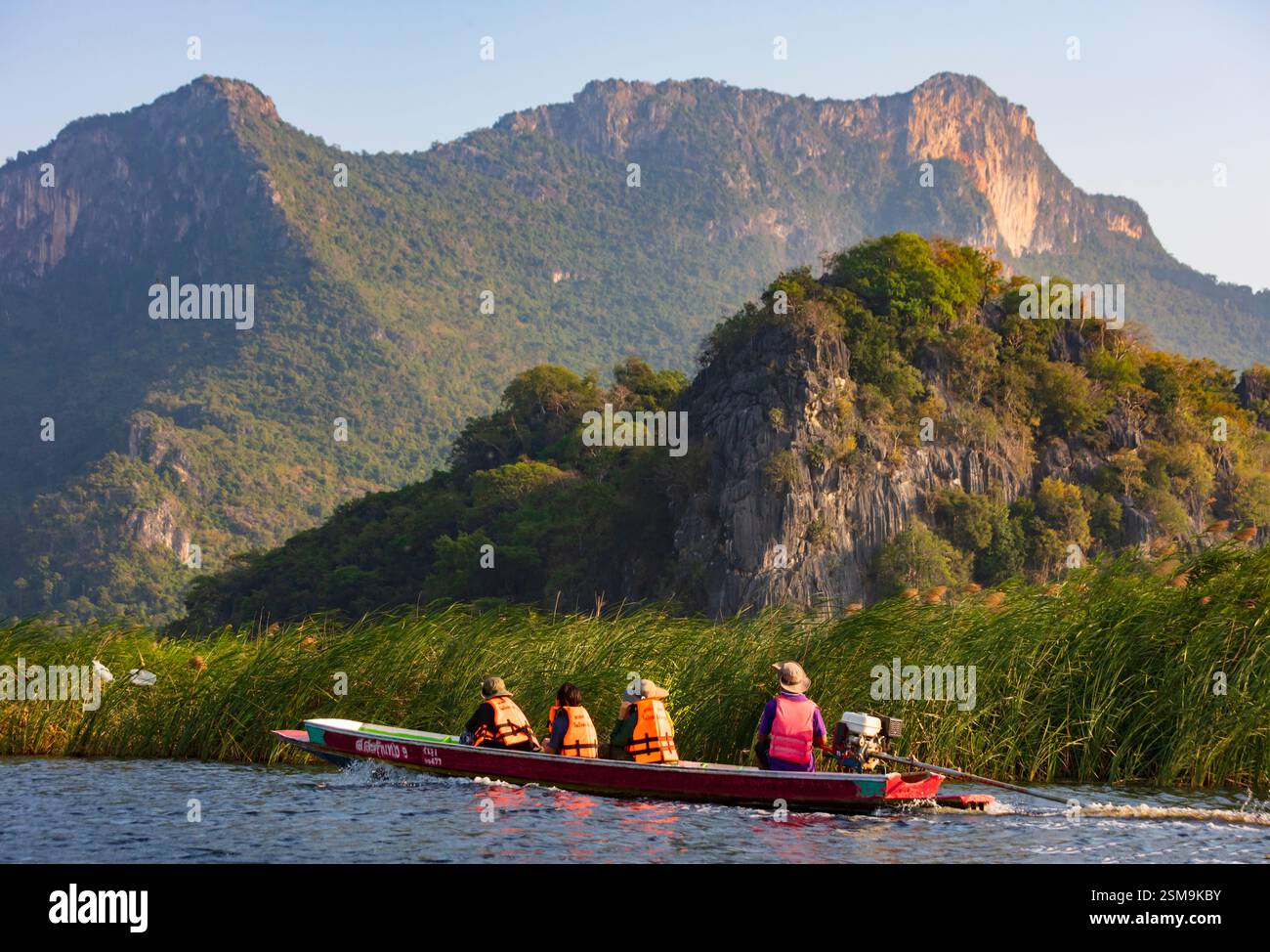 A boat ride surrounded bhy limestone mountains rising above the inland ...