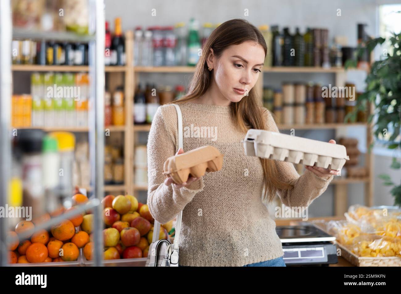 Positive pretty young woman choosing healthy eggs in supermarket Stock ...