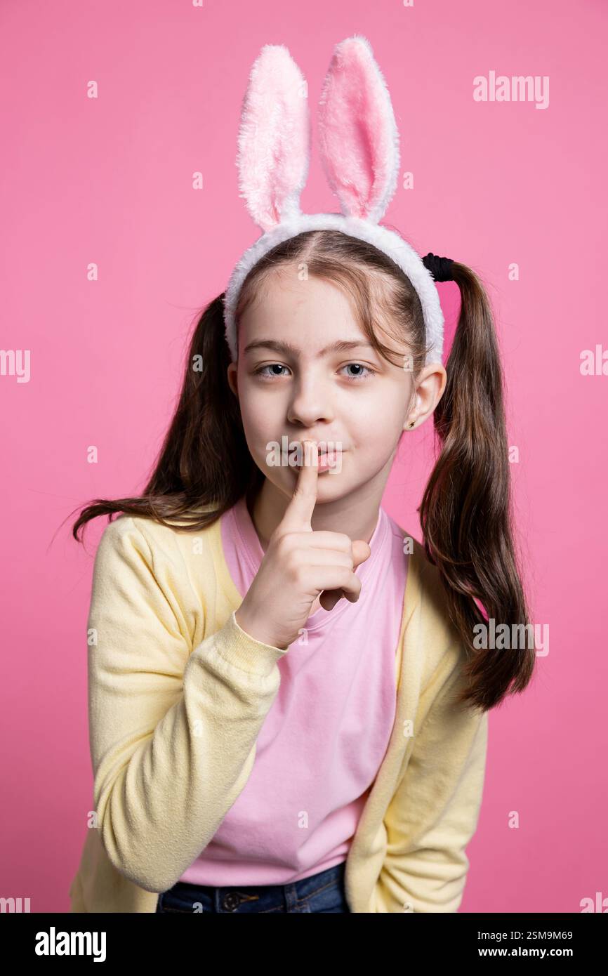Young child showing hush symbol in front of camera, feeling confident ...
