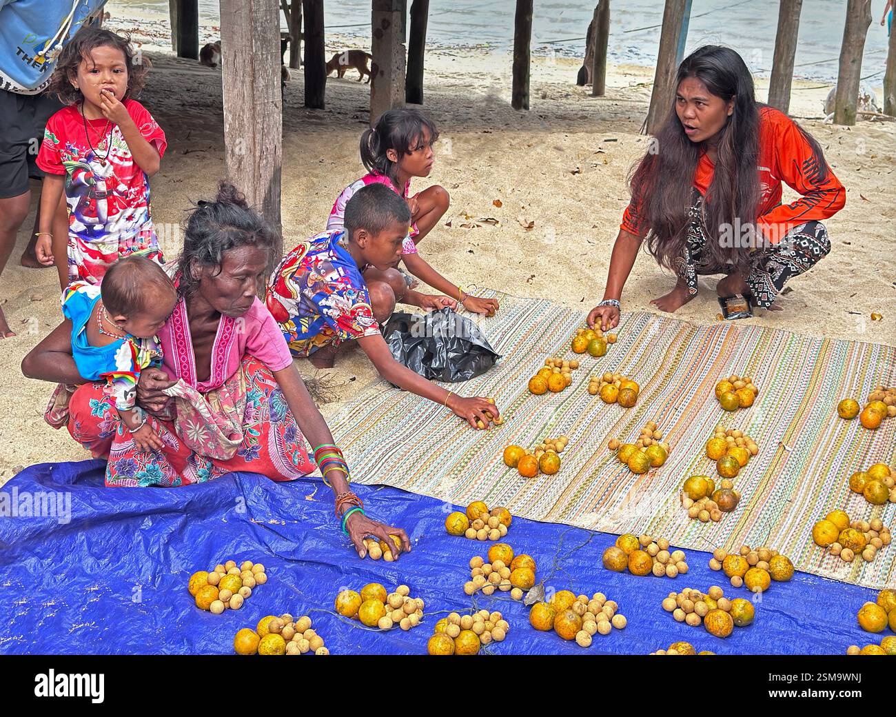 Moken Sea Gypsy people share fruit in the village of Ao Bon Yai on ...