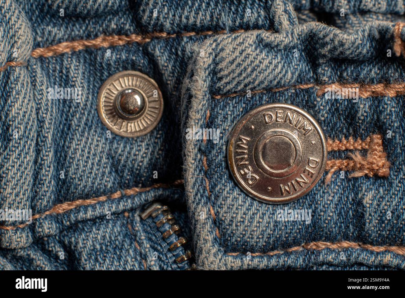 Button and seams of a denim garment. Denim trouser fabric in detail ...