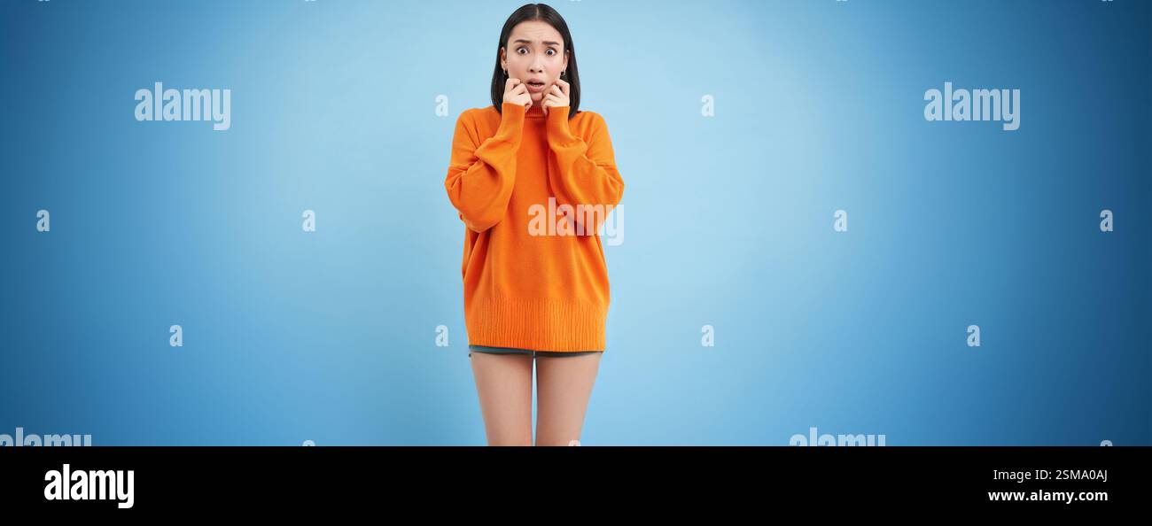 Korean woman with shocked, scared face expression, watches horror ...