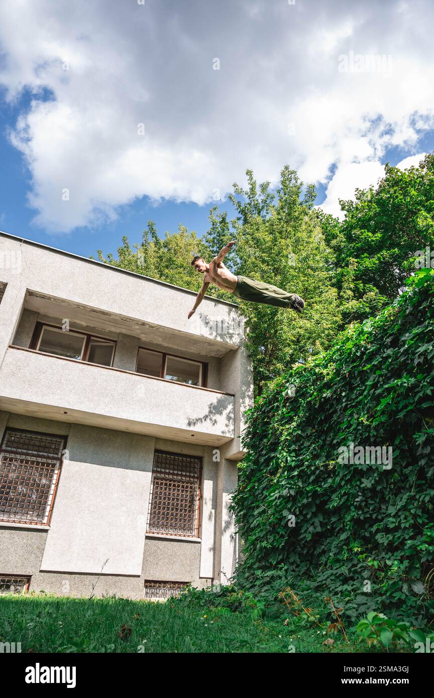 Man doing front flip from rooftop Stock Photo - Alamy