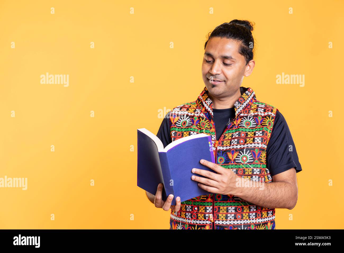 Indian man reading book, having fun and enjoying characters and plot ...