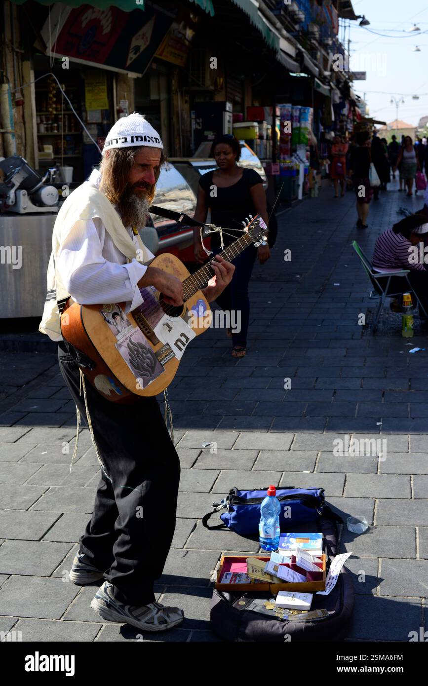 A Breslov Jewish man playing music at the Mahane Yehuda market in ...