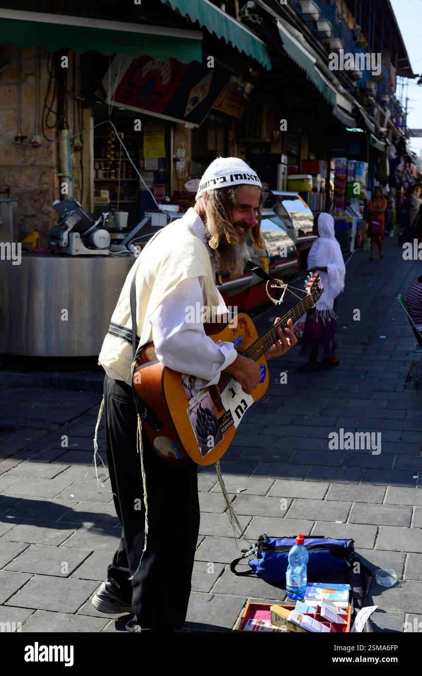 A Breslov Jewish man playing music at the Mahane Yehuda market in ...
