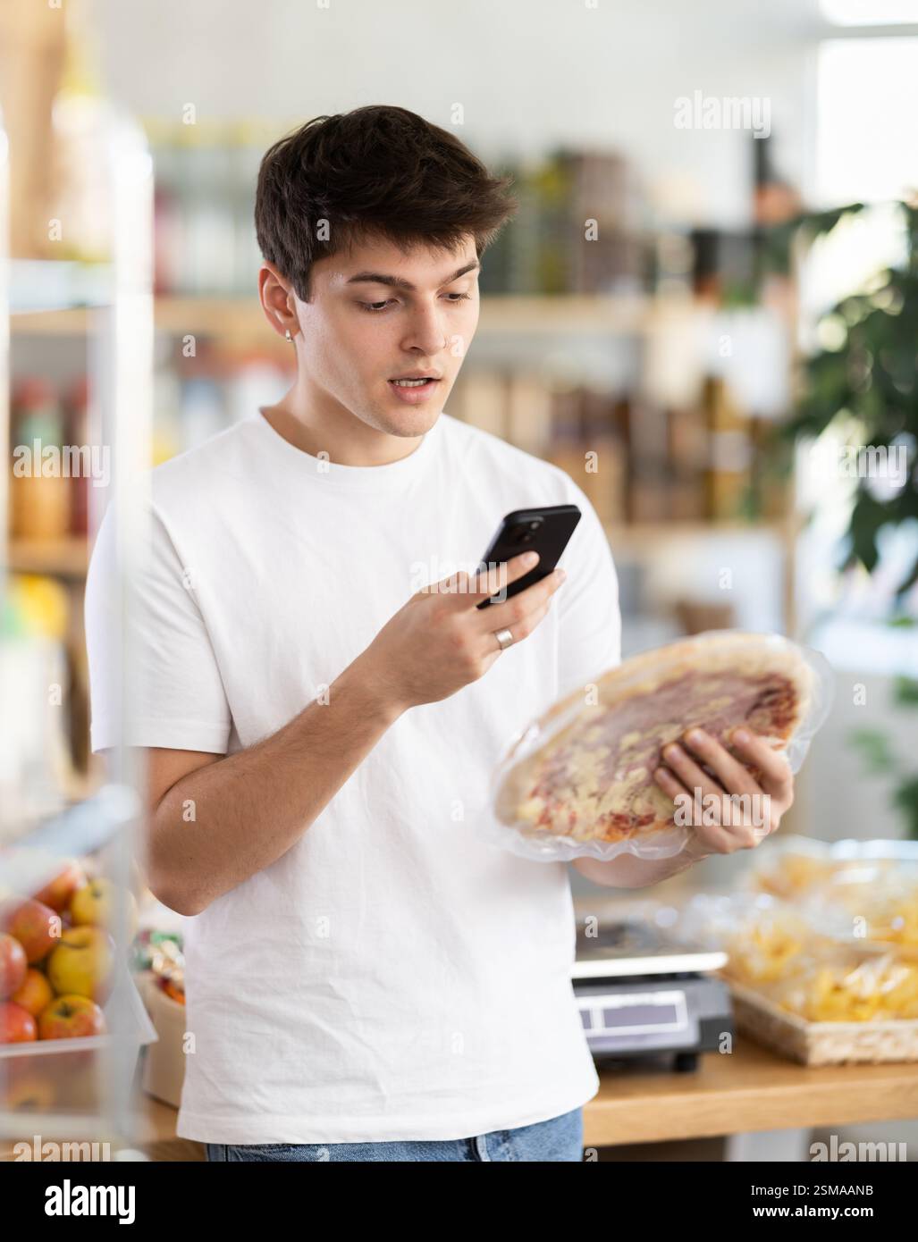 Male shopper scans QR code on four cheese pizza with smartphone Stock ...