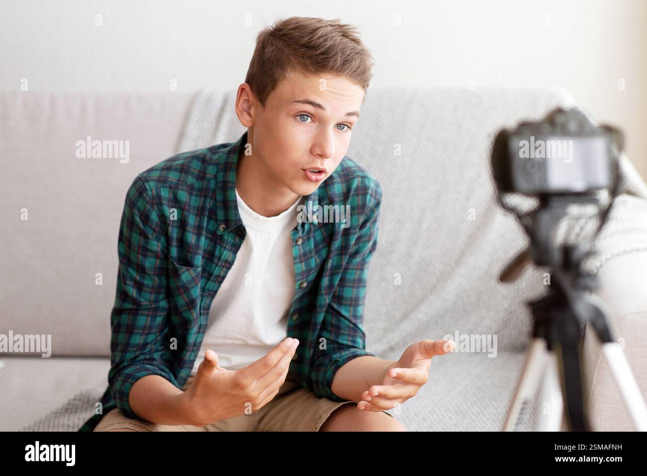 Teen blogger sharing his opinion with followers, shooting home video ...