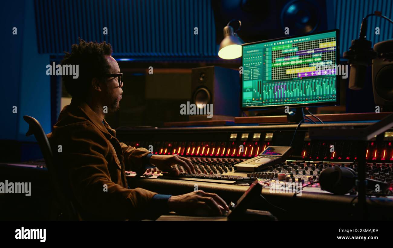 African american sound designer working with editing software to ...