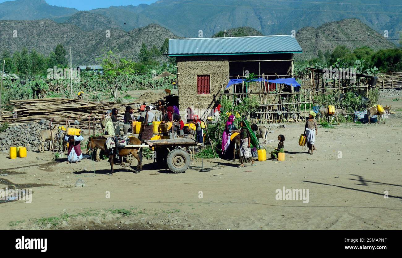 Villagers filling up jerrycans of water from a water pump station in a ...