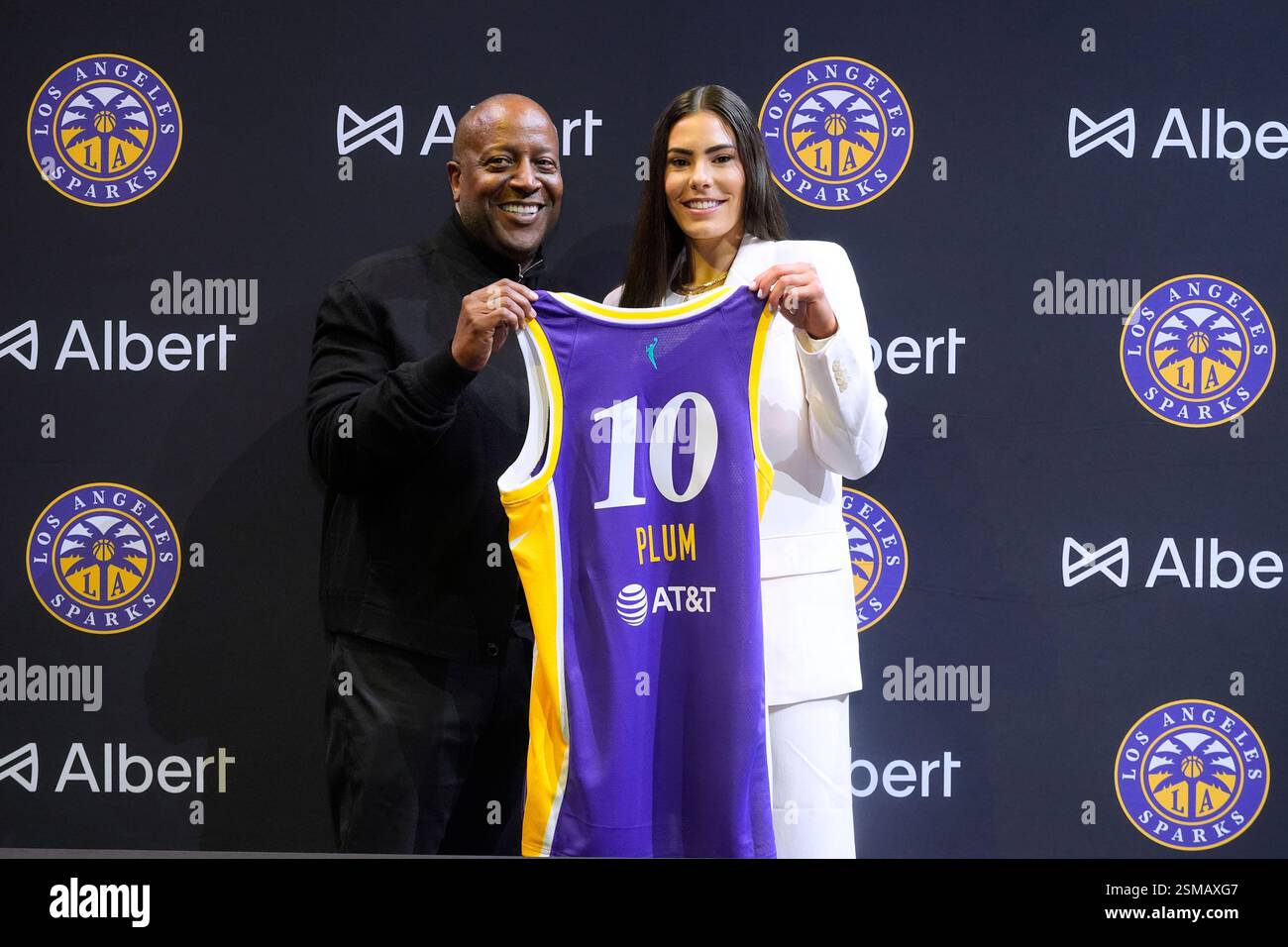 Los Angeles Sparks' Kelsey Plum, right, poses with her jersey with Sparks CEO Eric Holoman ...