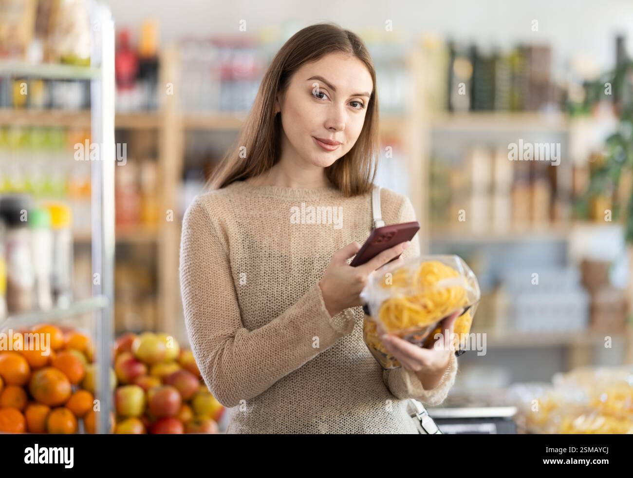 In shop young woman scans QR code and take reading on chips package ...