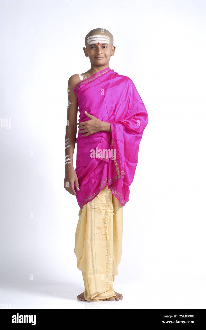 South Asian Indian bald boy in dhoti wearing pink cloth tilak on ...
