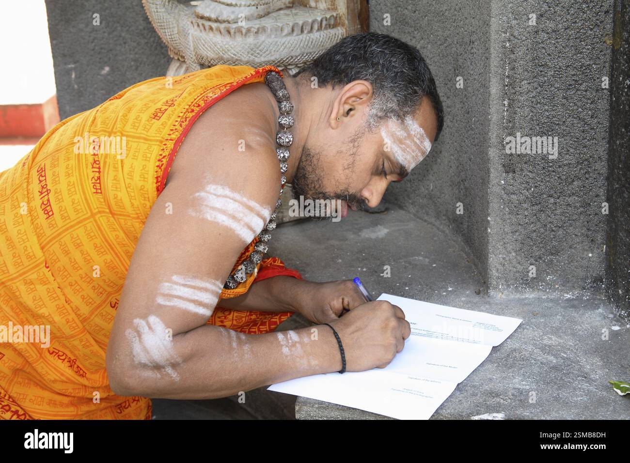 Religious preacher wearing rudraksha mala applying holy ash or bhasma ...