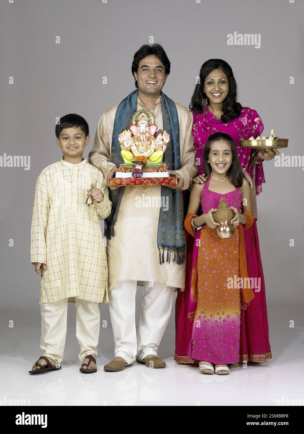 South Asian Indian family with father mother son and daughter holding ...