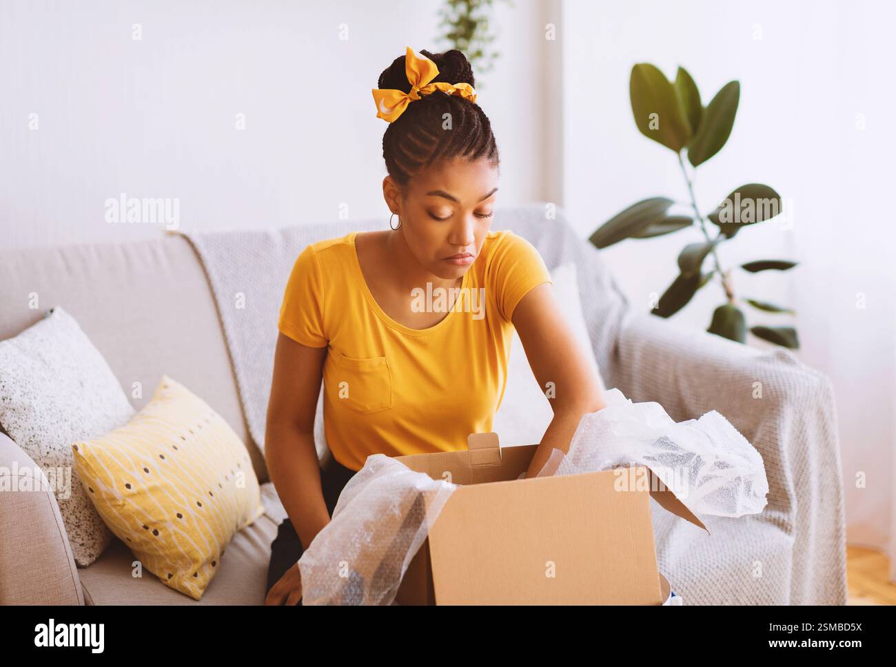 Frustrated black lady unpacking wrong parcel, delivery mistake Stock ...