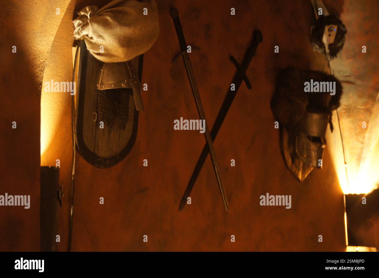 Medieval weapons and armor on a wall. A sword and a mace crossed over a ...