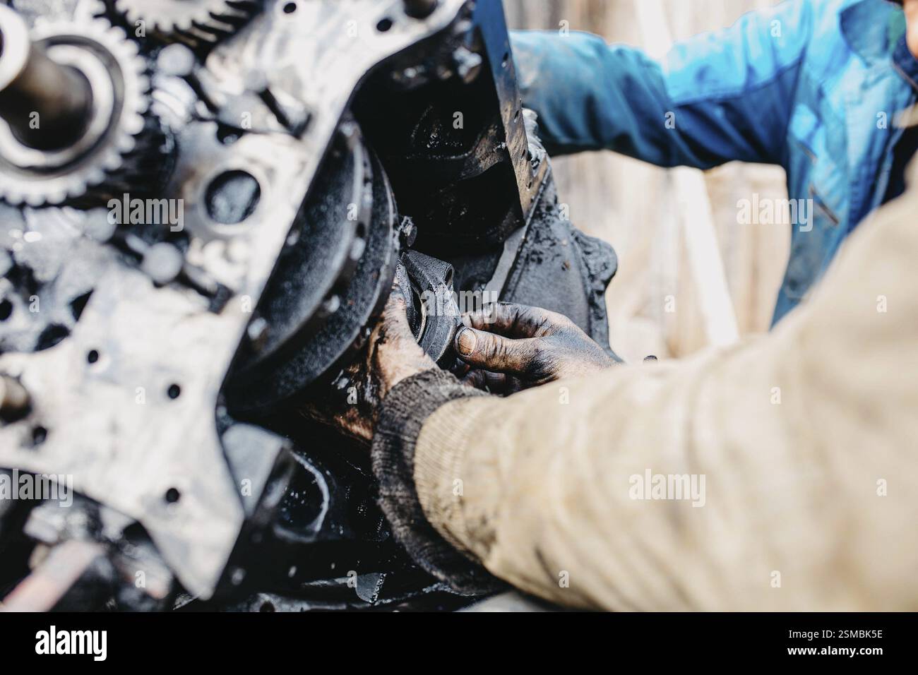 Hands working on engine repair, showing greasy parts and mechanical ...
