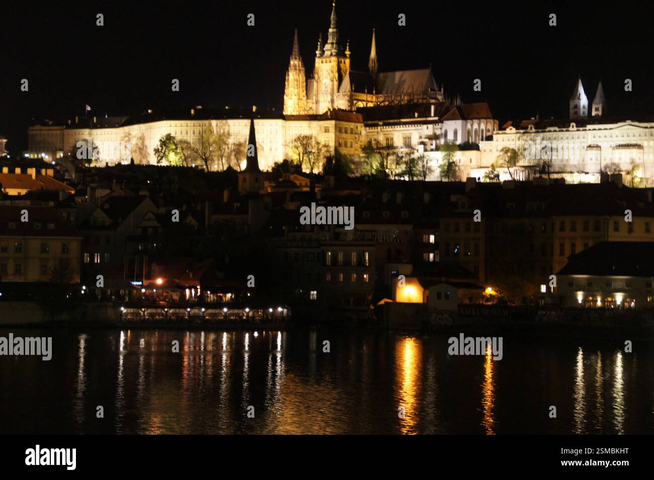 Prague Castle, illuminated spires and buildings along the Vltava River ...