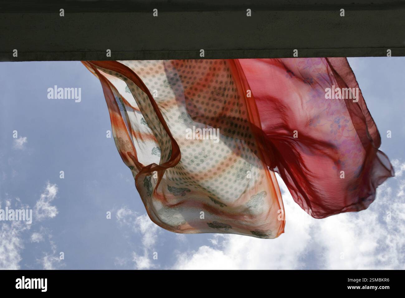 Indian traditional ladies wear saris flying in air against white clouds ...