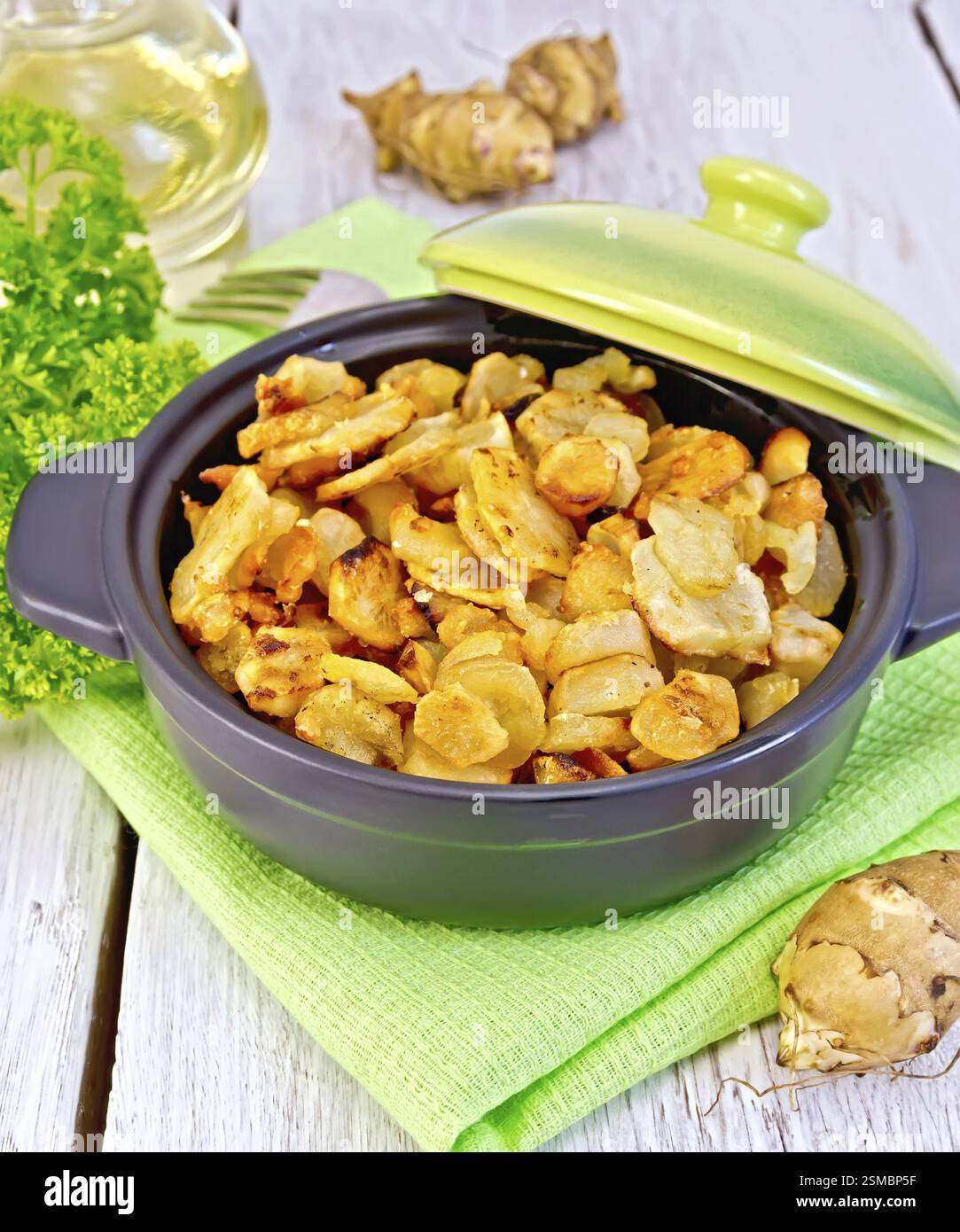 Jerusalem artichokes roasted in a roasting pan with a lid, fresh tubers ...