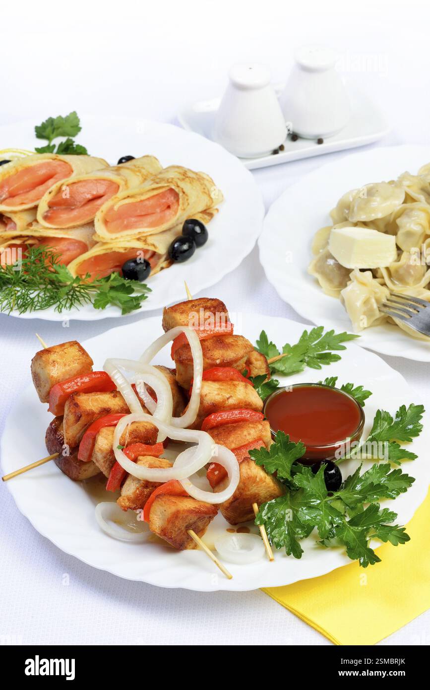 Food with meat, salmon rolls and dumplings. Table with white background ...