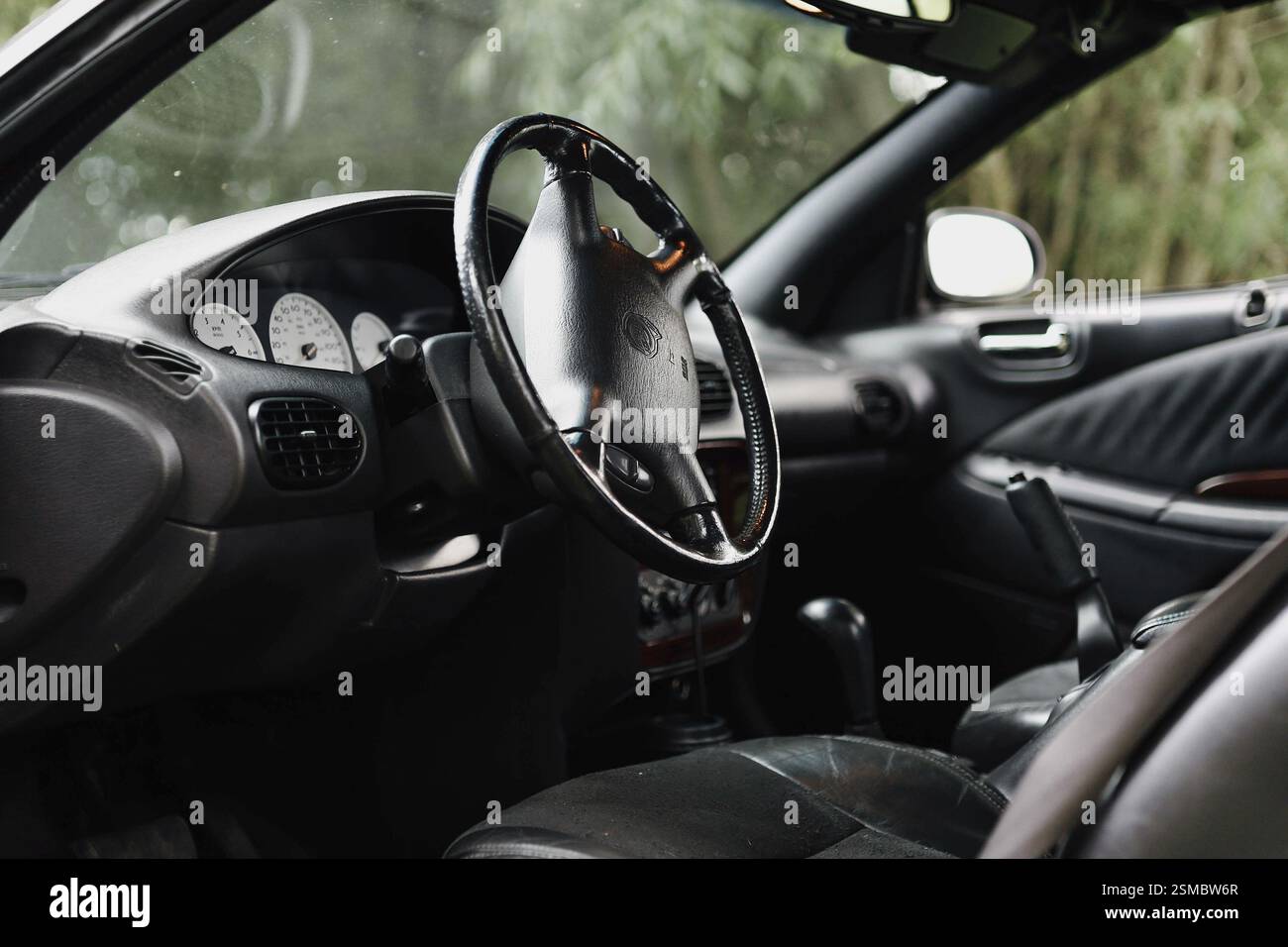 Close-up of a car's steering wheel and dashboard with leather seats ...