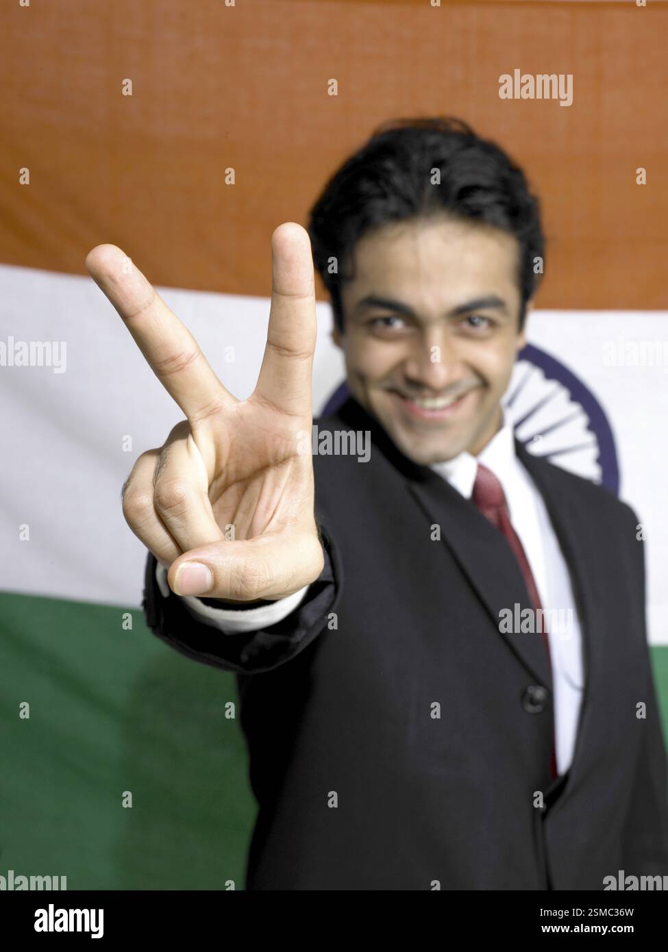 South Asian Indian executive showing victory sign standing in front of ...