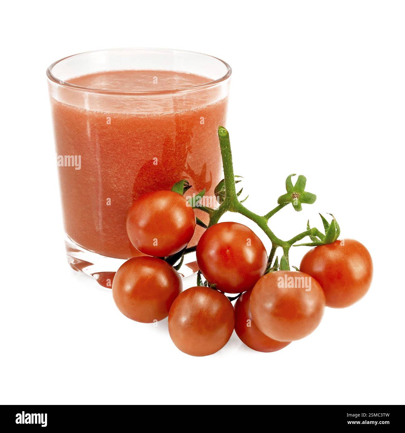 Tomato juice in low broad glass with a cluster of small tomatoes ...