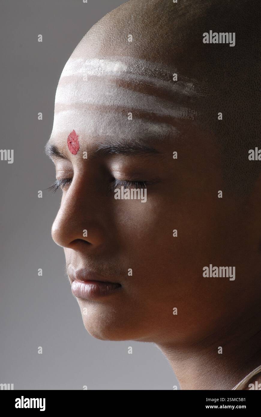 Portrait of South Asian Indian bald boy red tilak on forehead close ...