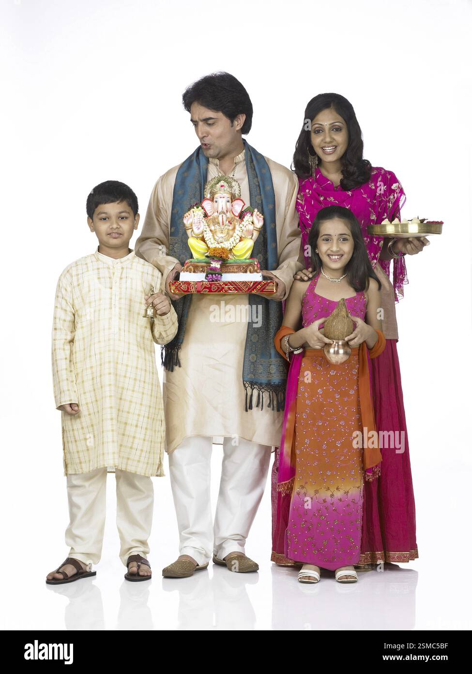 South Asian Indian family with father mother son and daughter holding ...