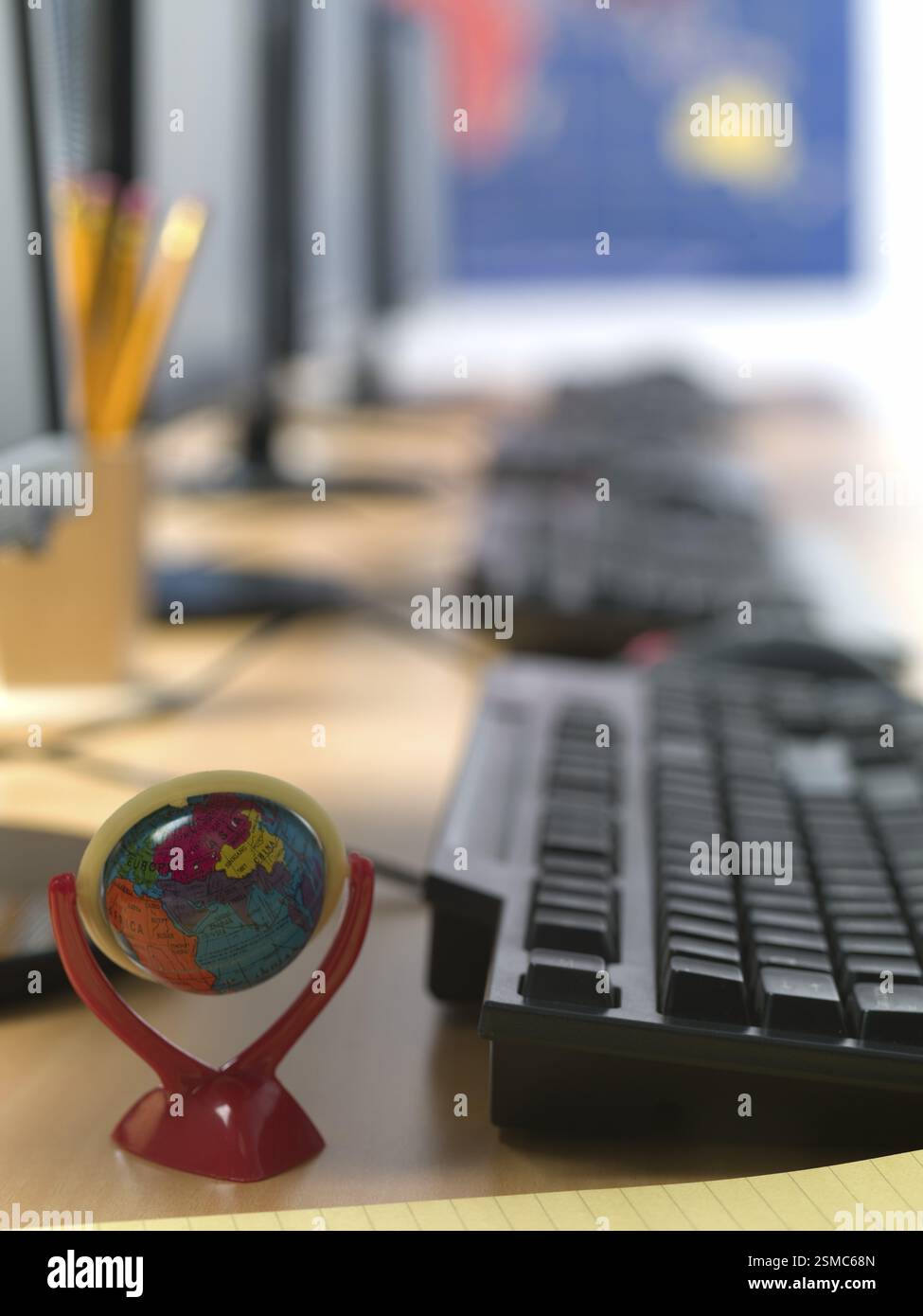 Keyboard with globe on desk in office Stock Photo - Alamy
